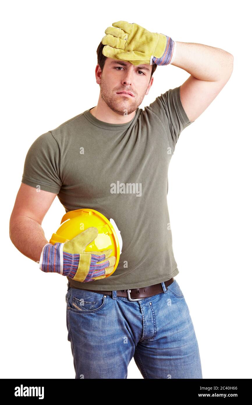 Exhausted construction worker with helmet in hand wipes his forehead ...