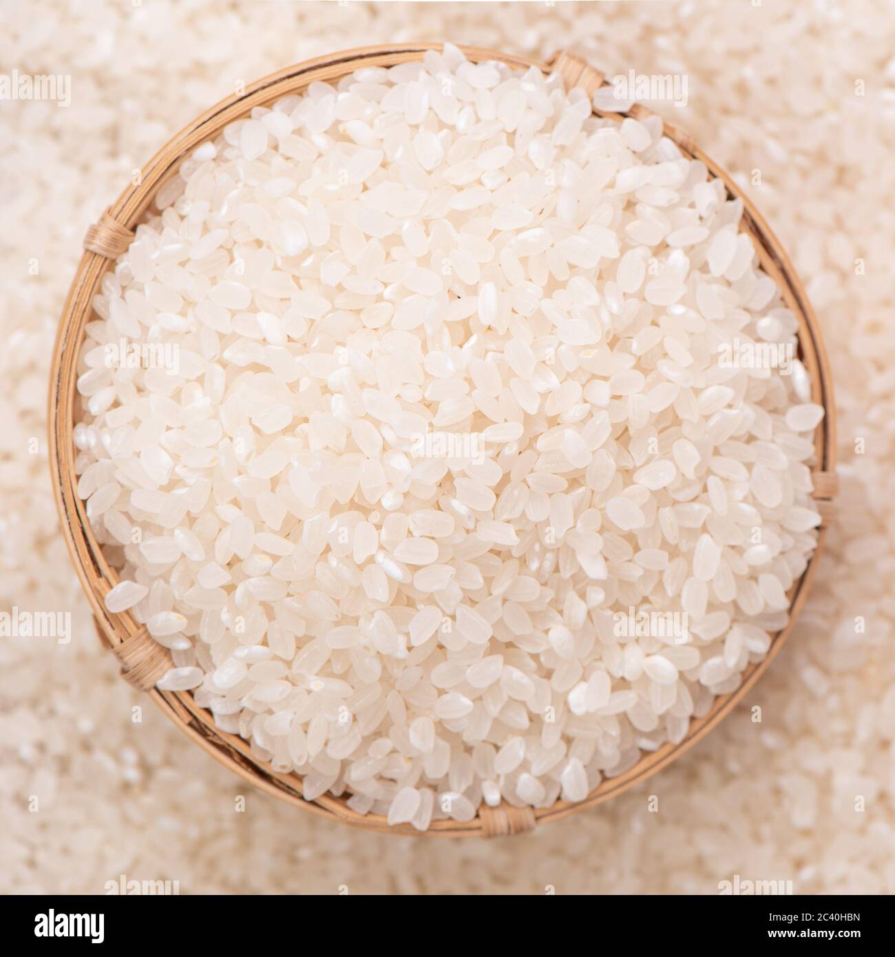 Raw rice in a bowl and full frame in the white background table, top ...