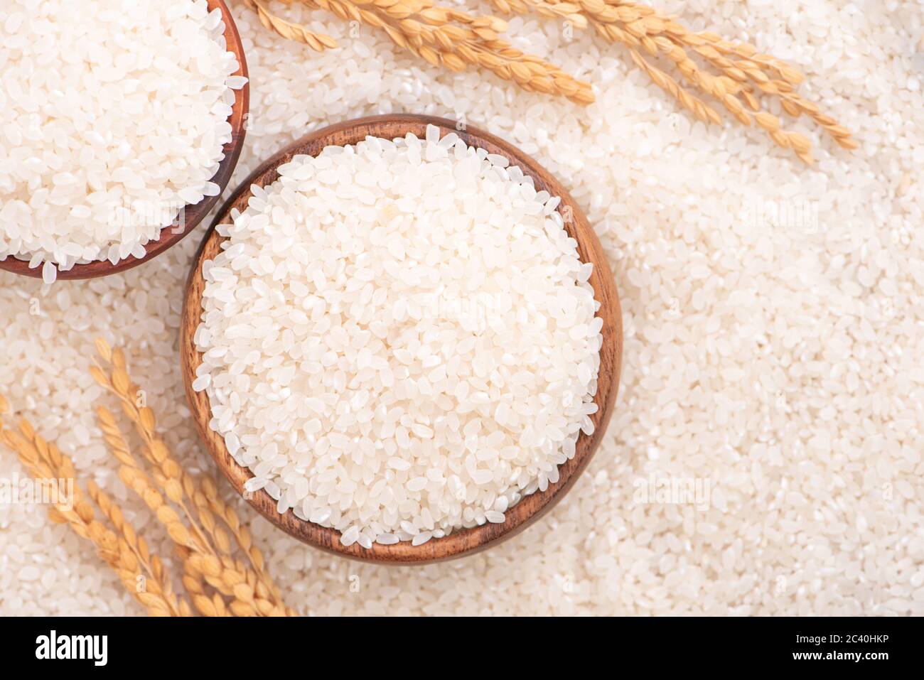 Raw rice in a bowl and full frame in the white background table, top ...