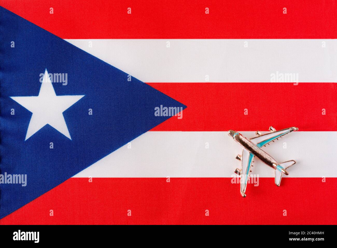 Airplane over the flag of Puerto Rico travel concept. Toy plane on a ...