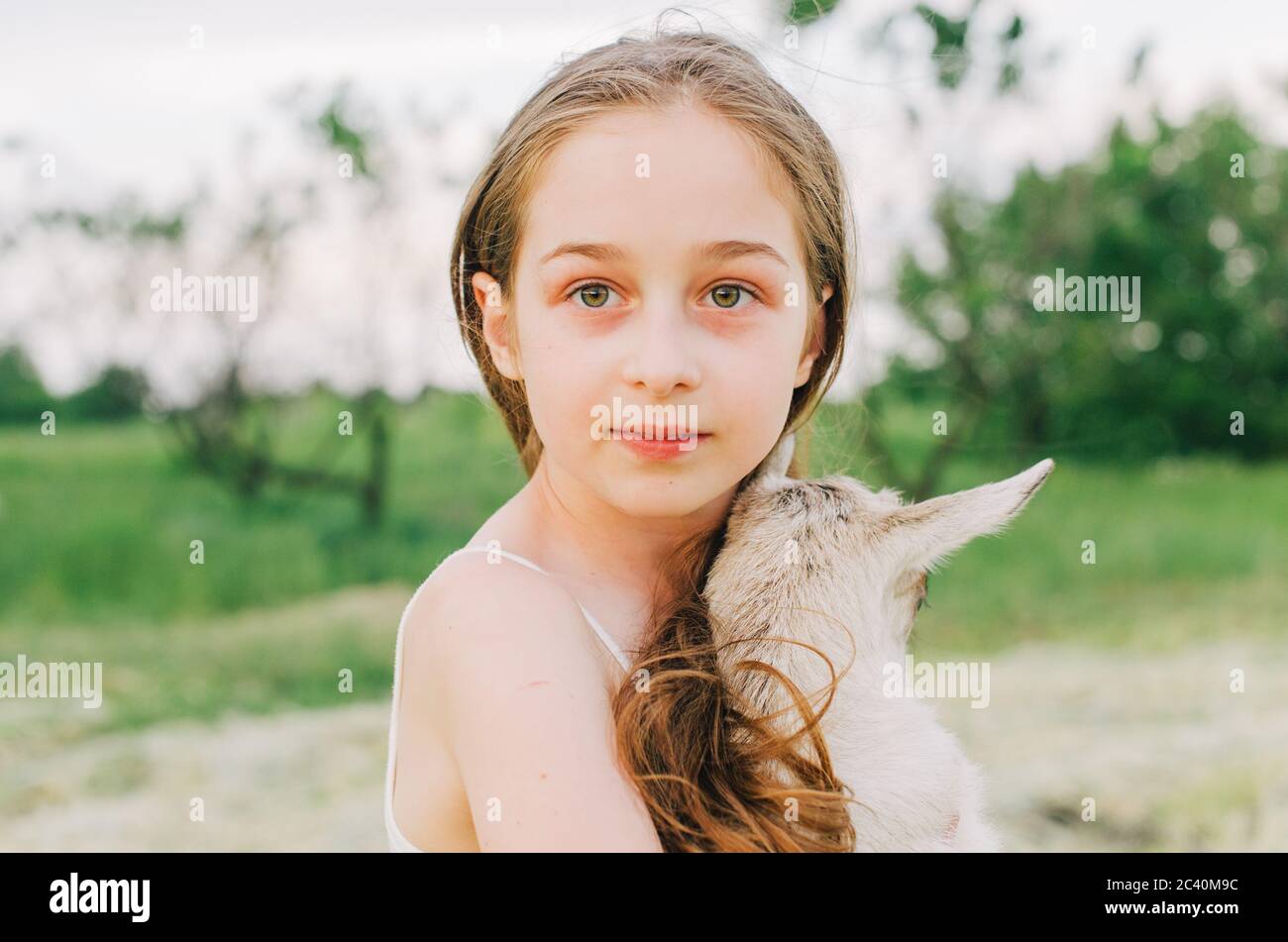 girl with baby goat on farm outdoors. Love and care. Village animals ...