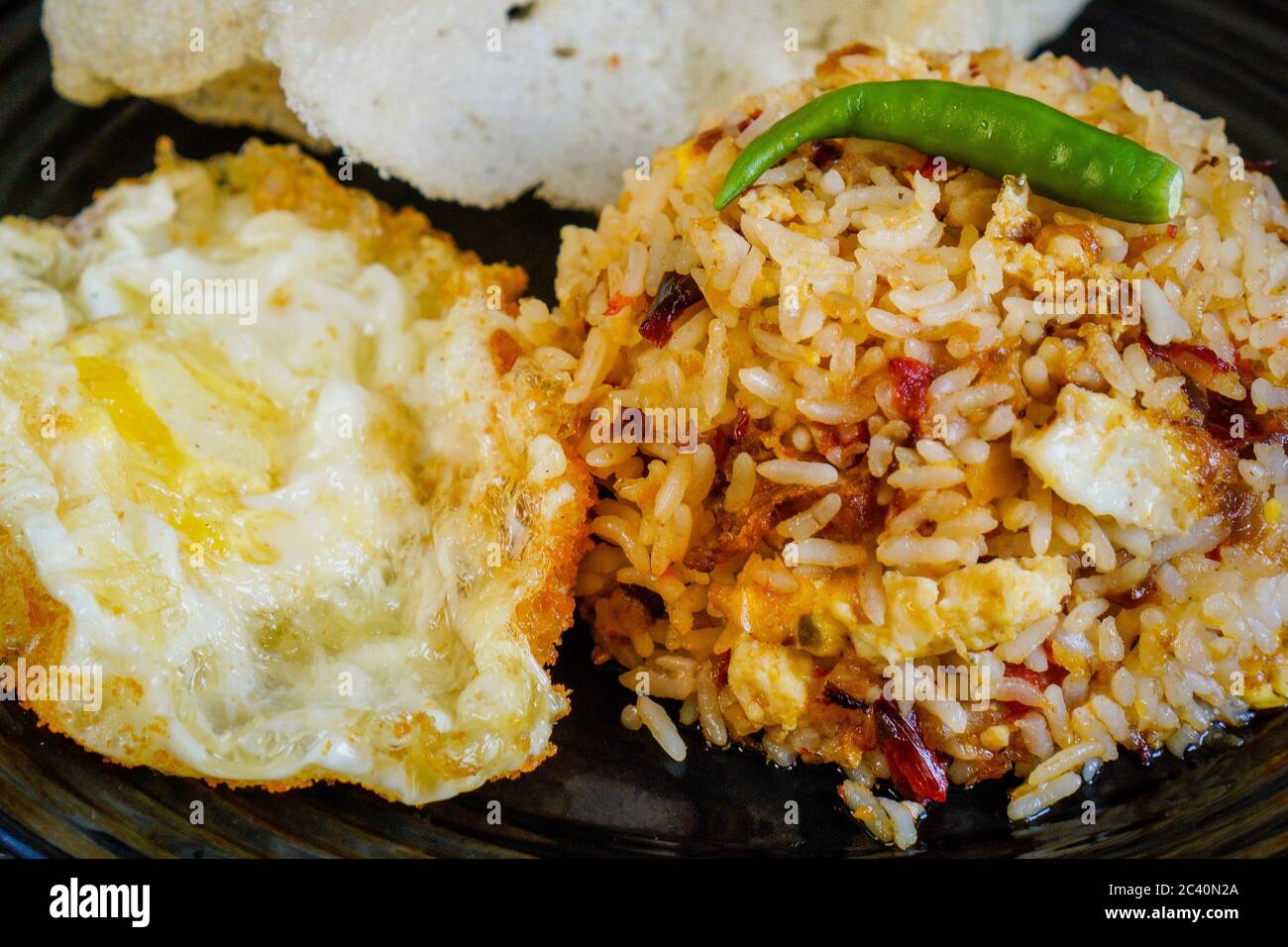 Spicy fried rice with dried chilli with fried egg and fish cracker ...
