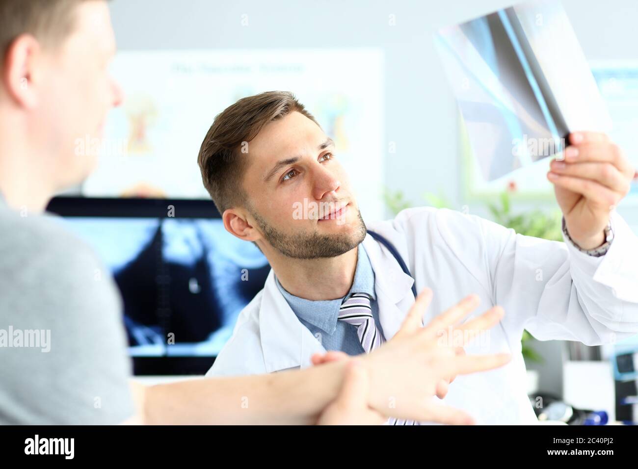 Handsome young doctor checking X-ray image in clinic Stock Photo - Alamy