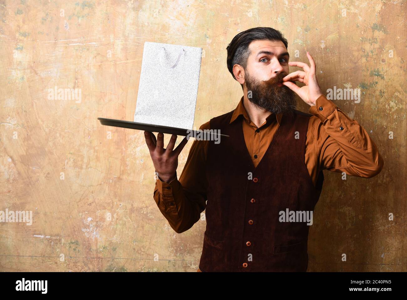 Waiter serving a present or shopping bag on tray showing Perfect taste ...