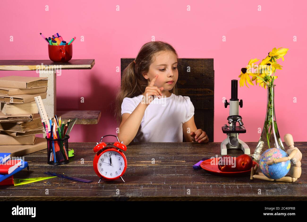 Childhood and study time concept. Kid and school supplies on pink wall ...