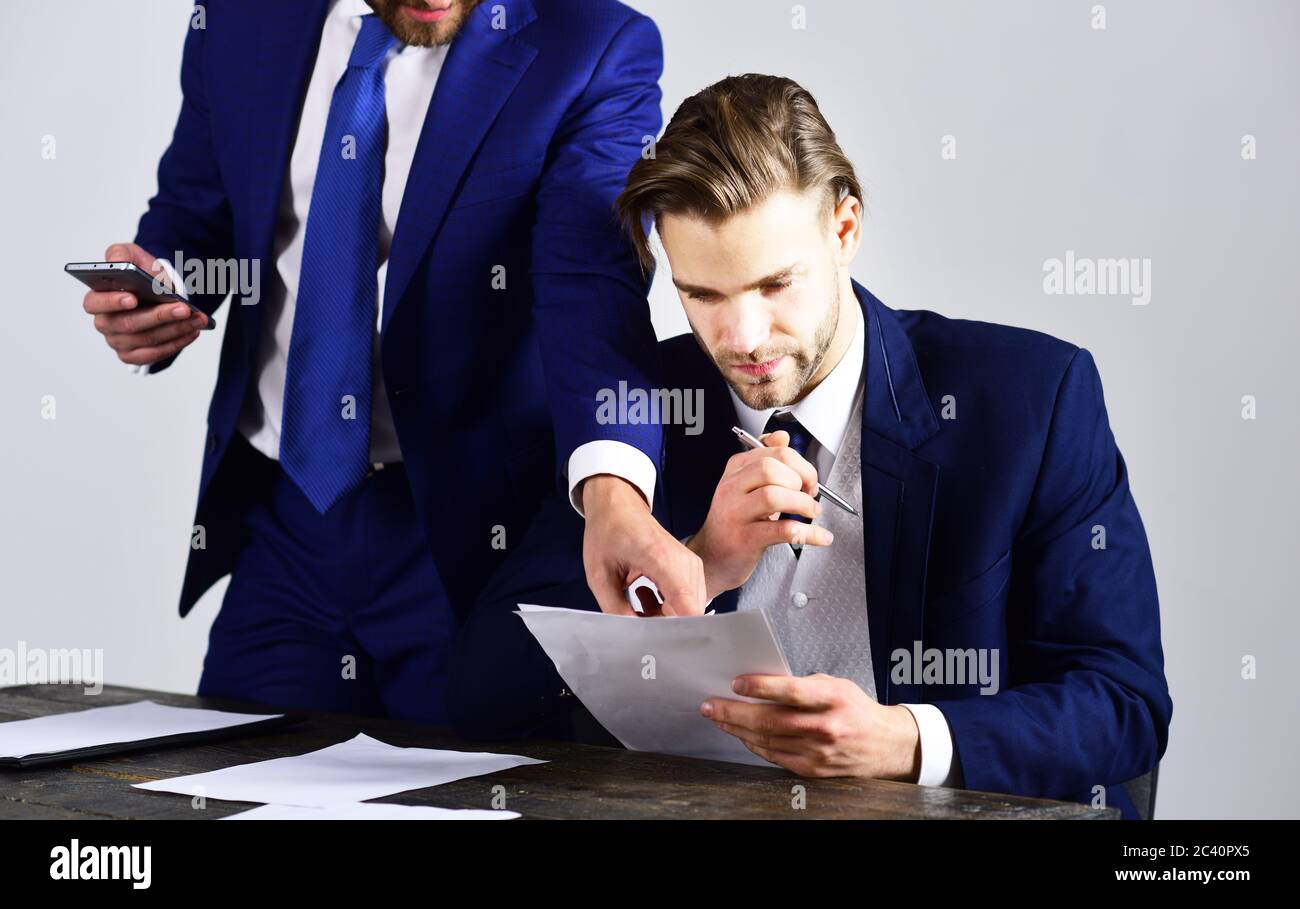 Boss talking to assistant. Director helps young worker with documents ...