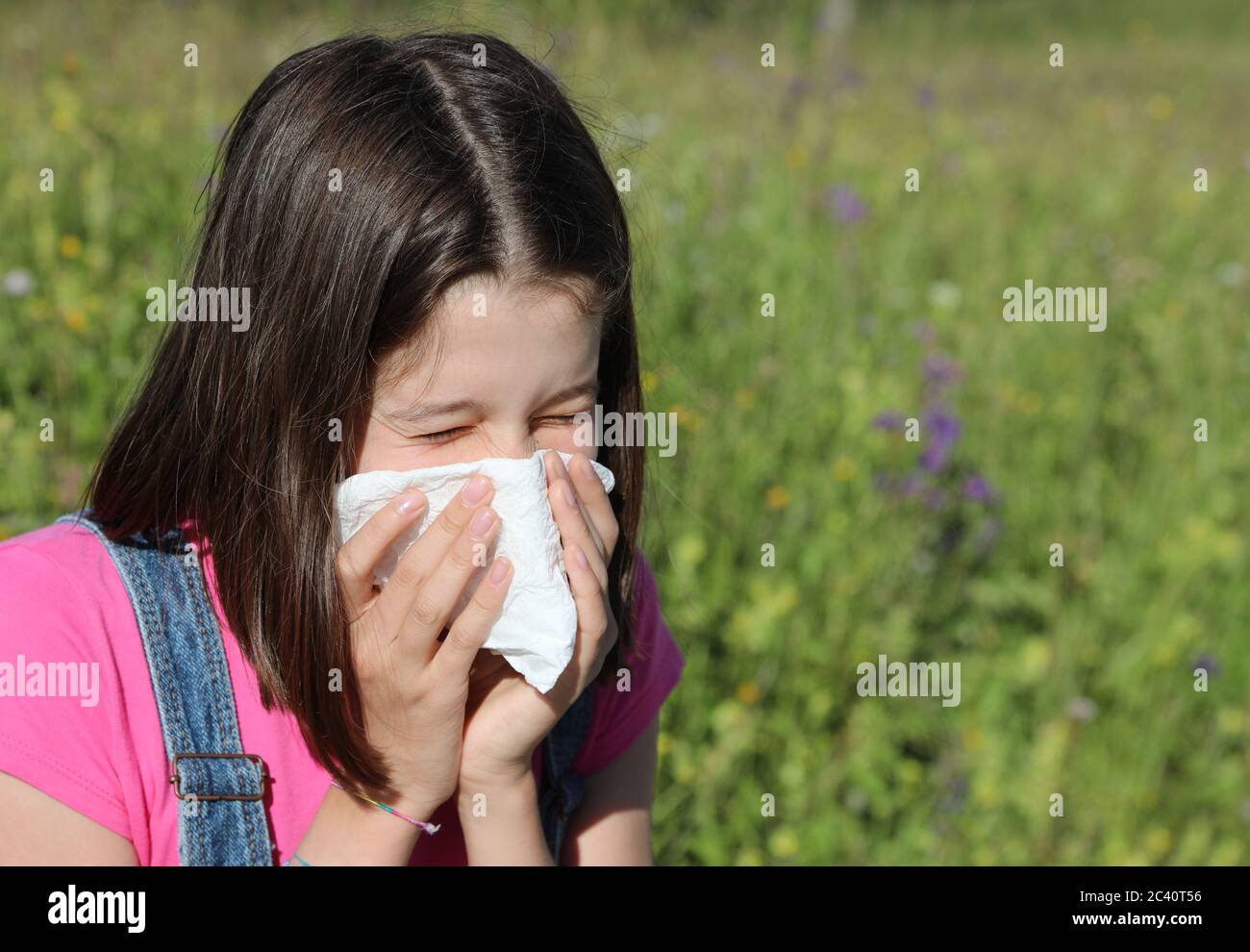 young girl sneezes and blows her nose with white handkerchief in a flowery field Stock Photo - Alamy