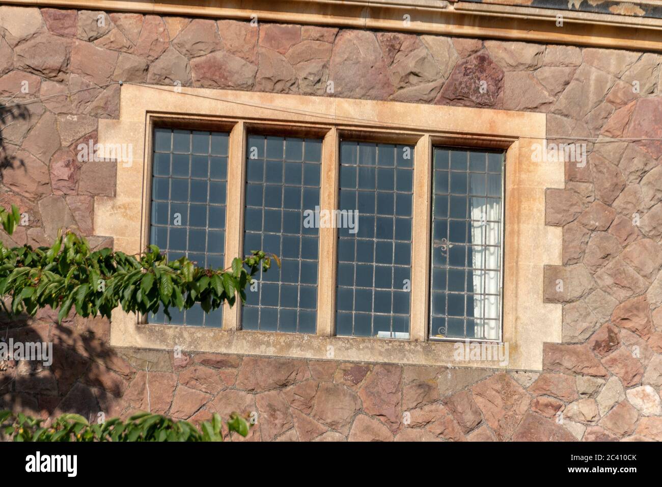 A close up view of a glass window on the side of a stone house Stock ...