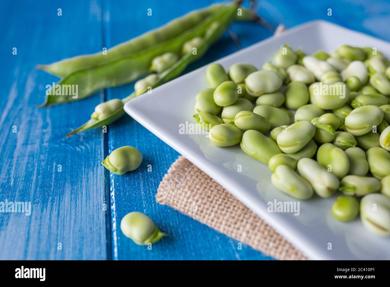 Fava beans in white plate on rustic table Stock Photo - Alamy