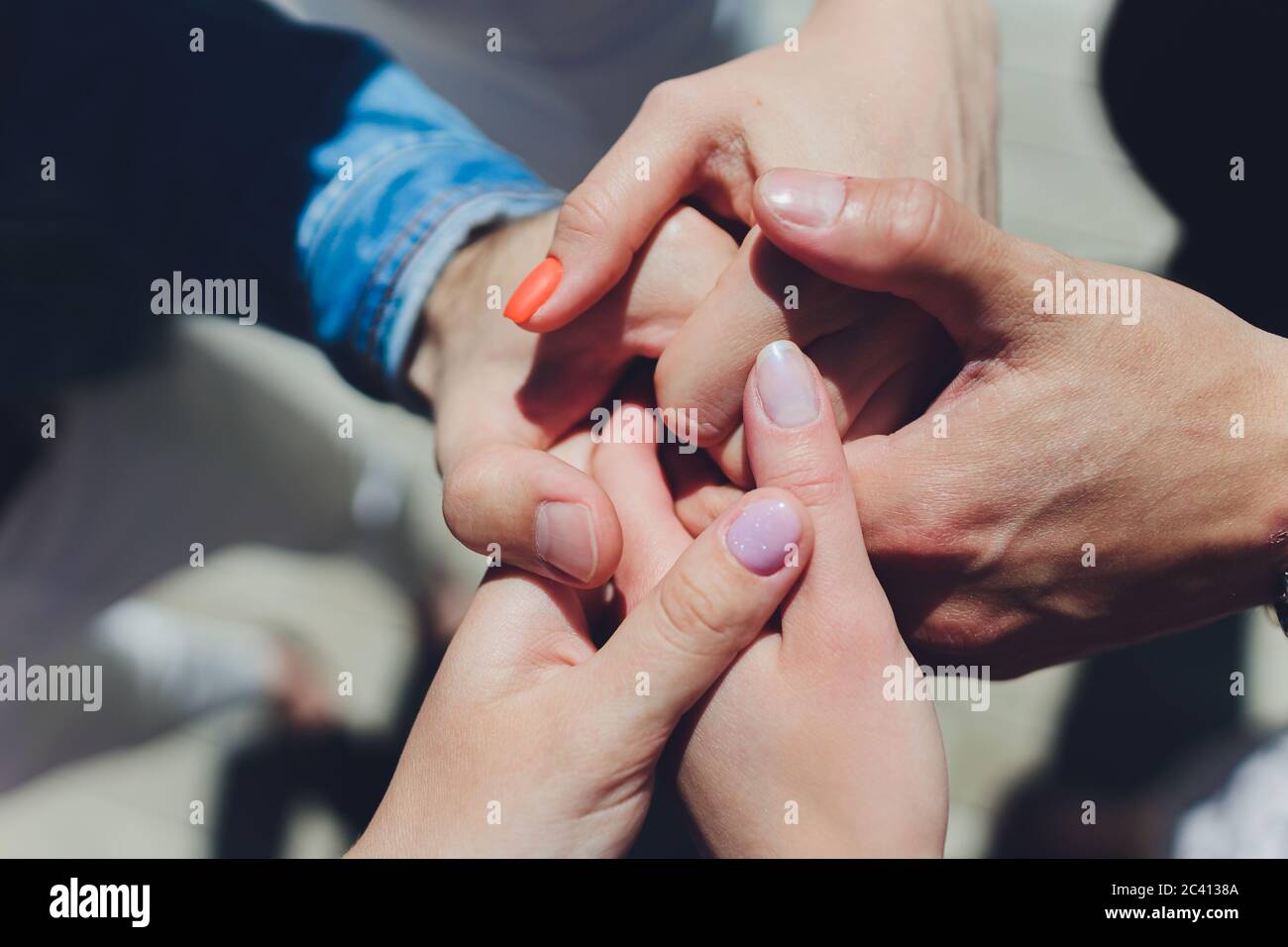 two man and three women holding hands on a table implying a polyamory ...