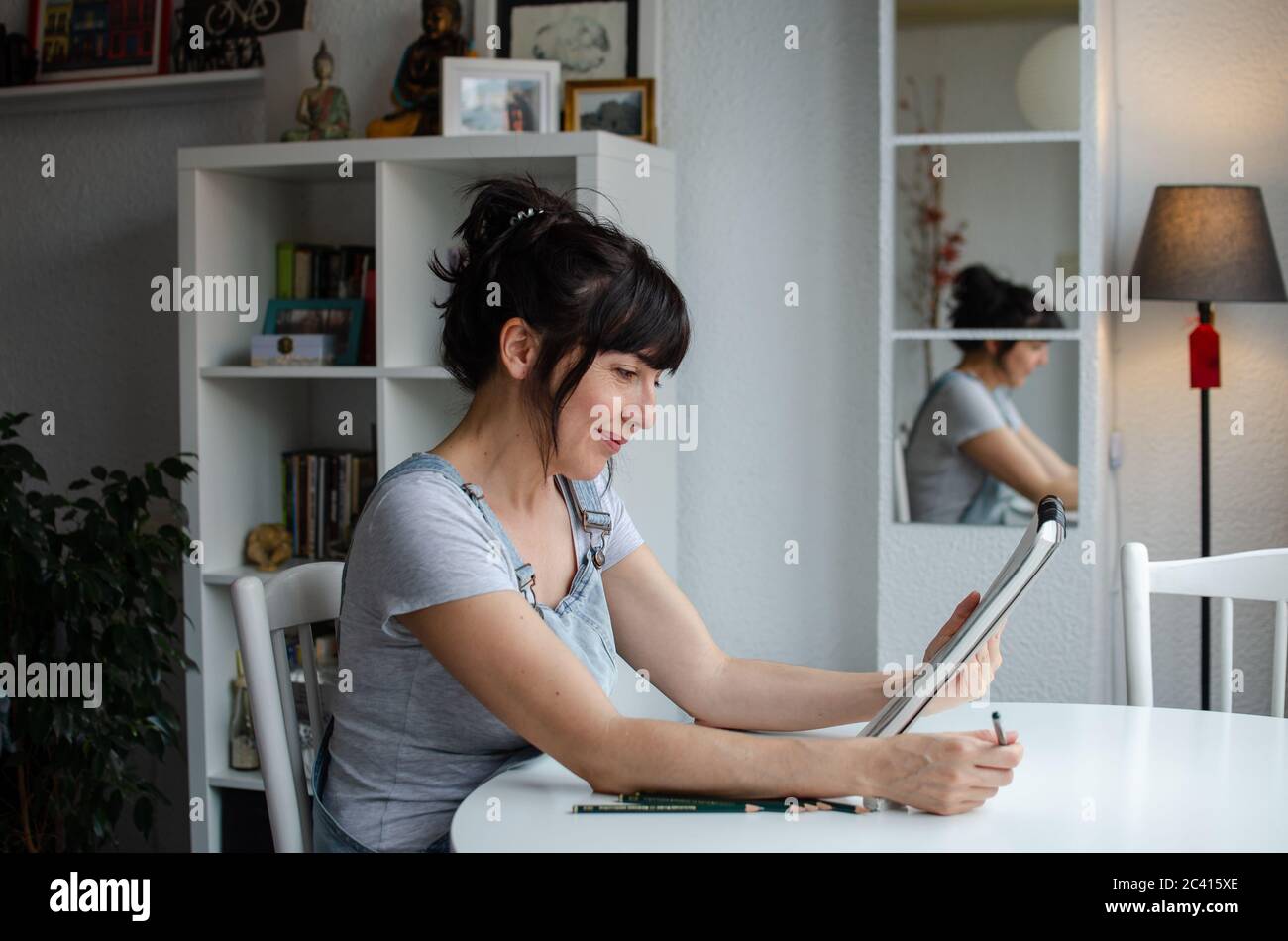 White woman drawing in a sketchpad at home Stock Photo - Alamy