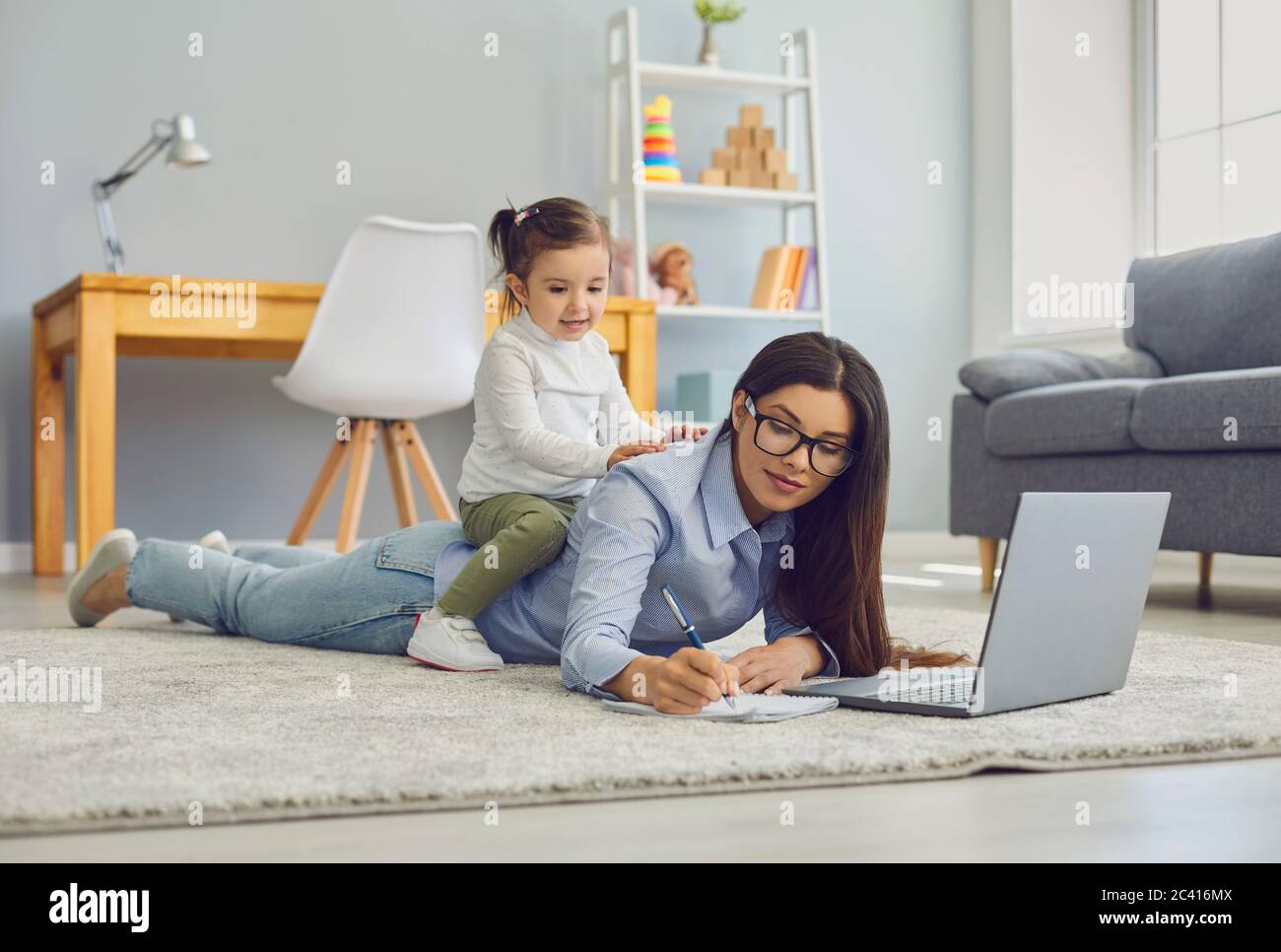 Multitasking for work at home moms. Young woman doing online job on ...
