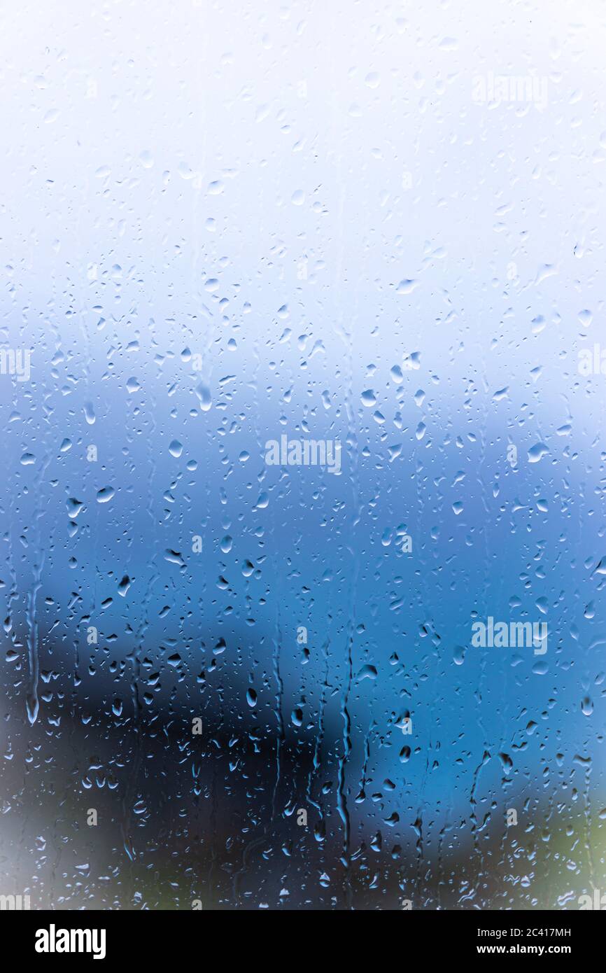Raindrops on window glass with blur background Stock Photo - Alamy