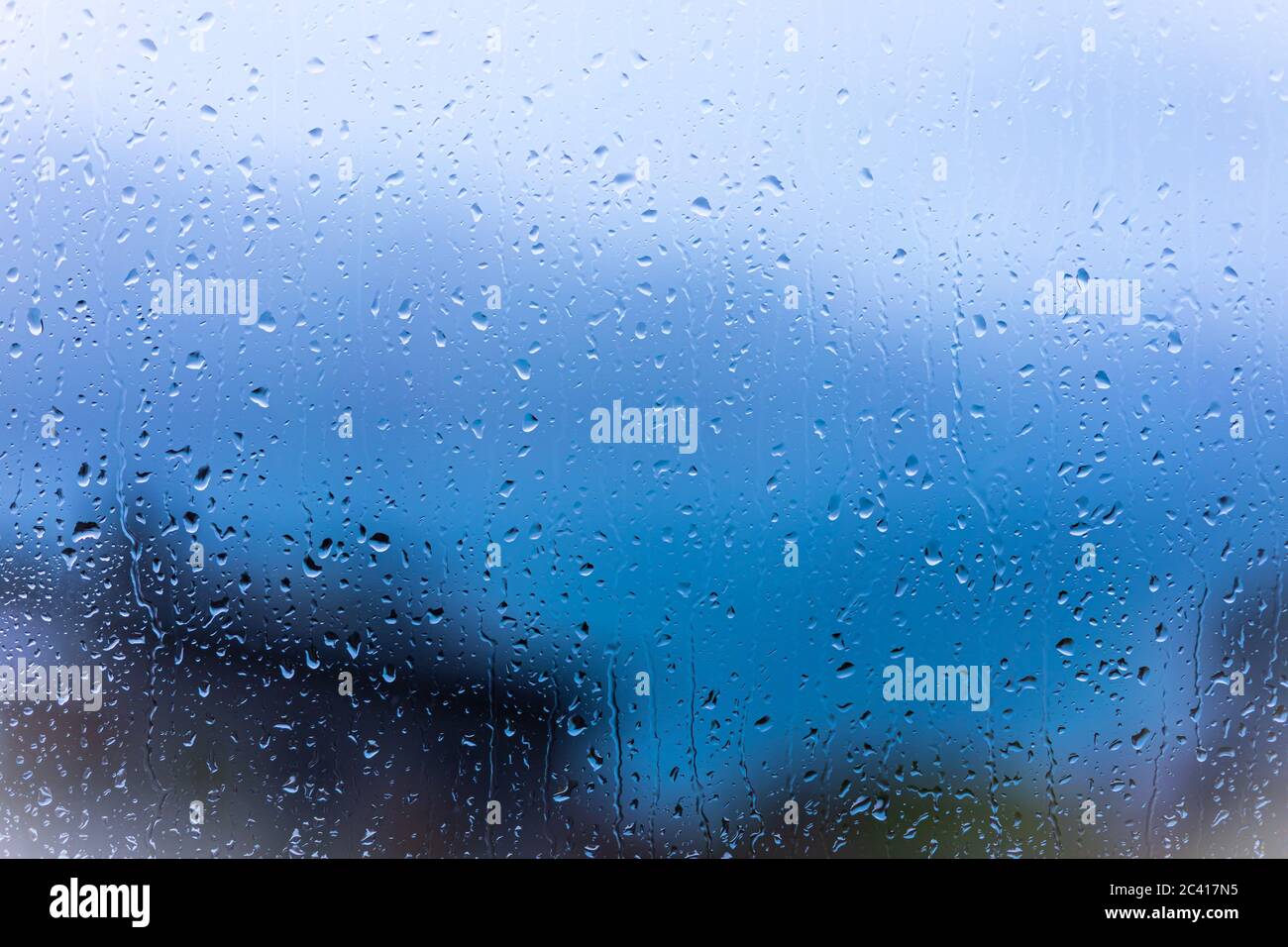 Raindrops on window glass with blur background Stock Photo - Alamy