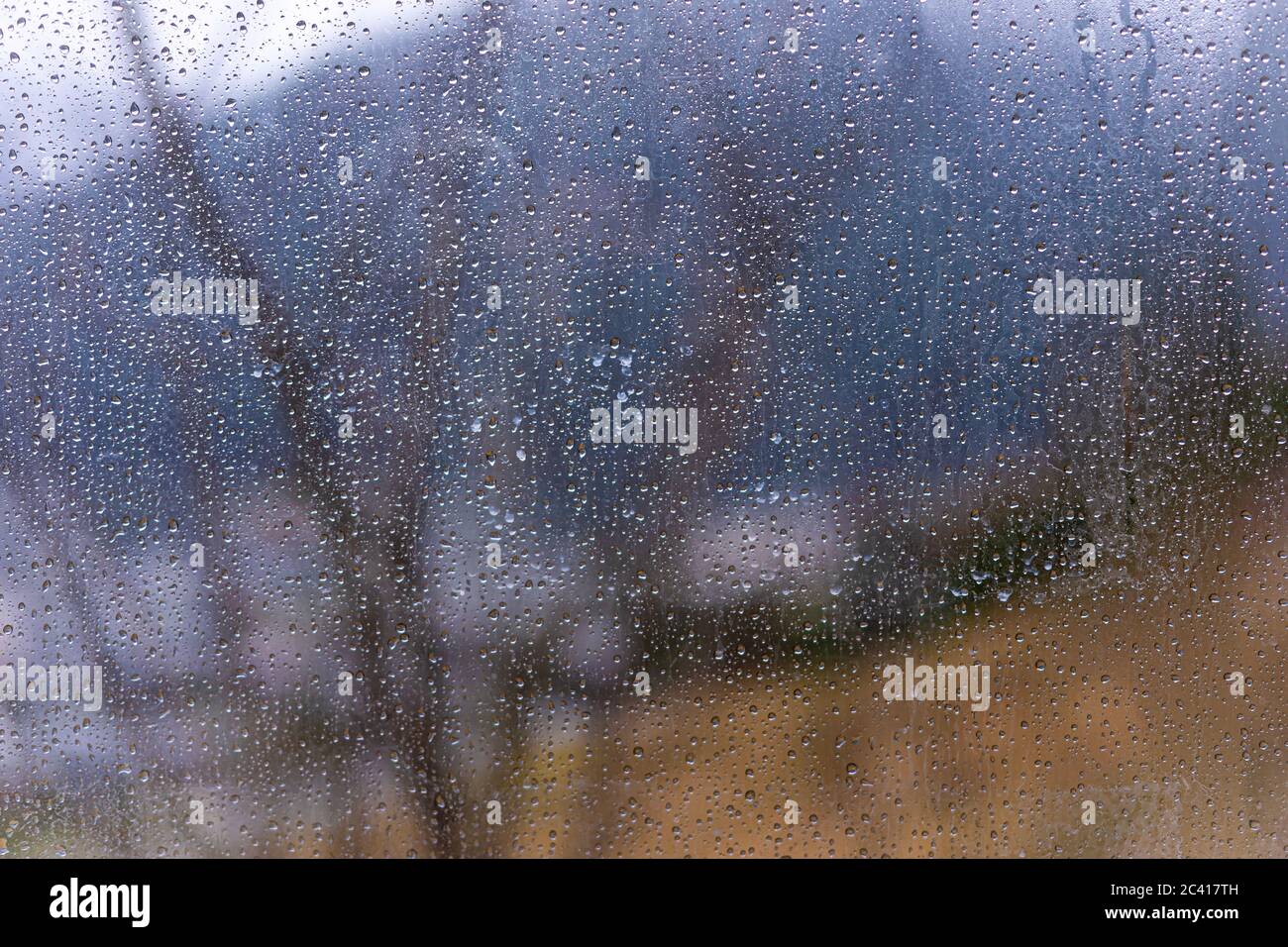 Raindrops on window glass with blur background Stock Photo - Alamy