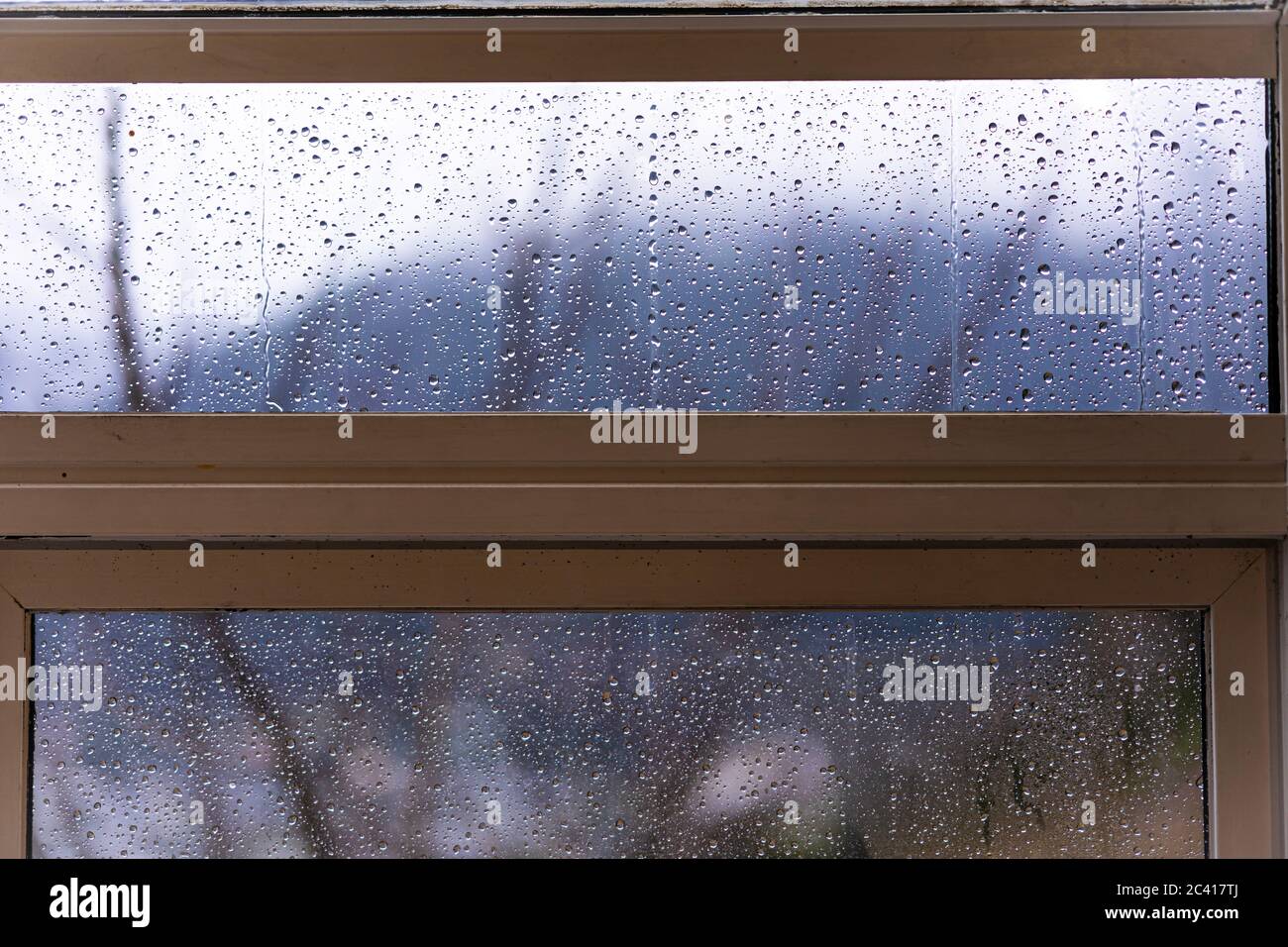 Raindrops on window glass with blur background Stock Photo - Alamy