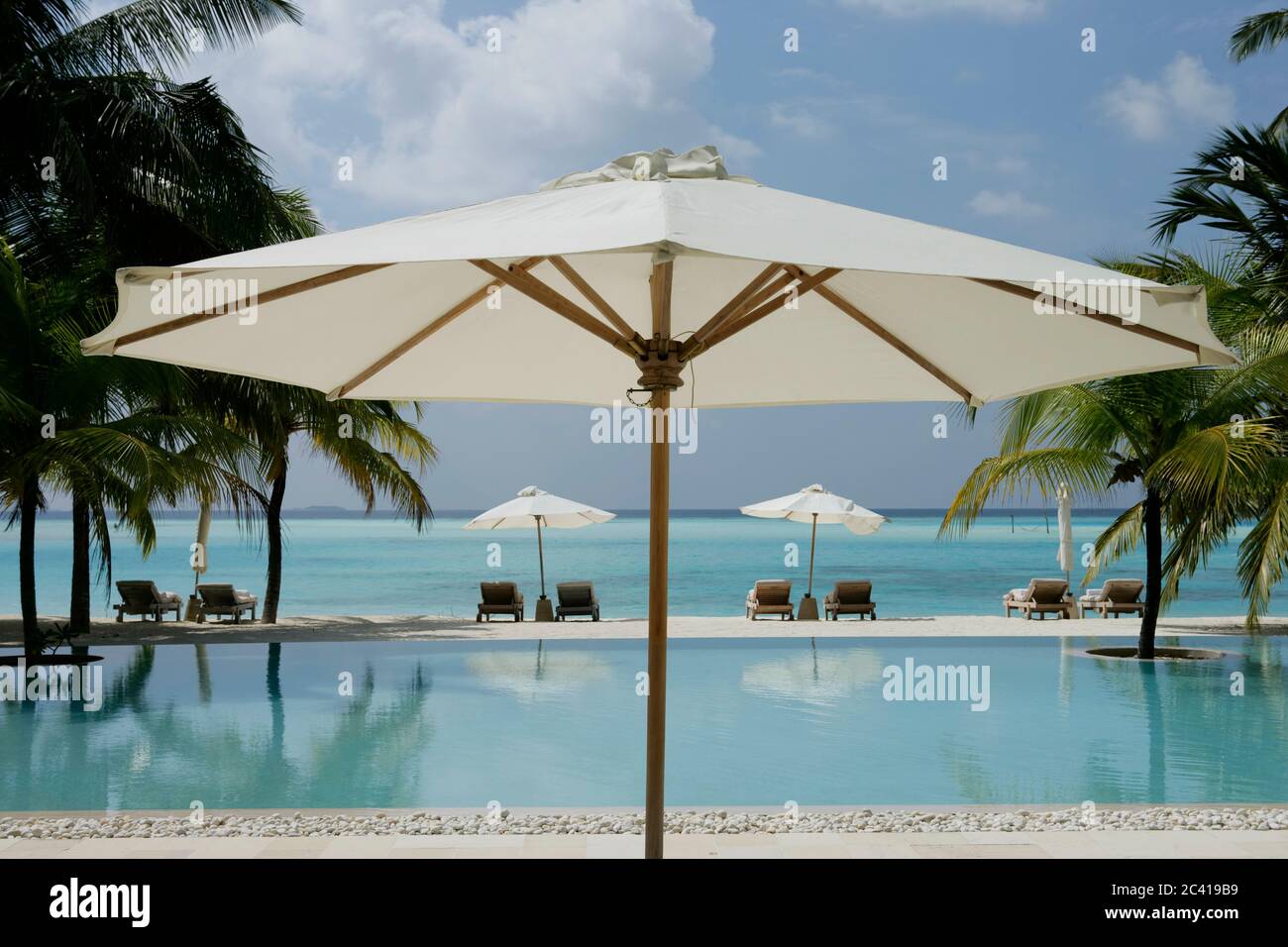 Parasols and sun beds by the pool Stock Photo - Alamy