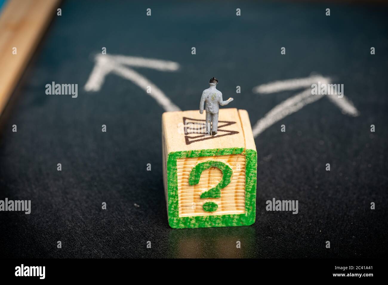 Business concept: Decision making. Miniature man on chalkboard with two ...