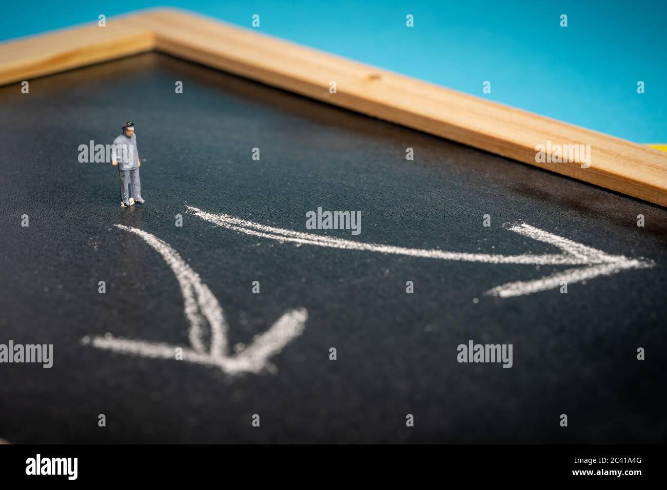Business concept: Decision making. Miniature man on chalkboard with two ...
