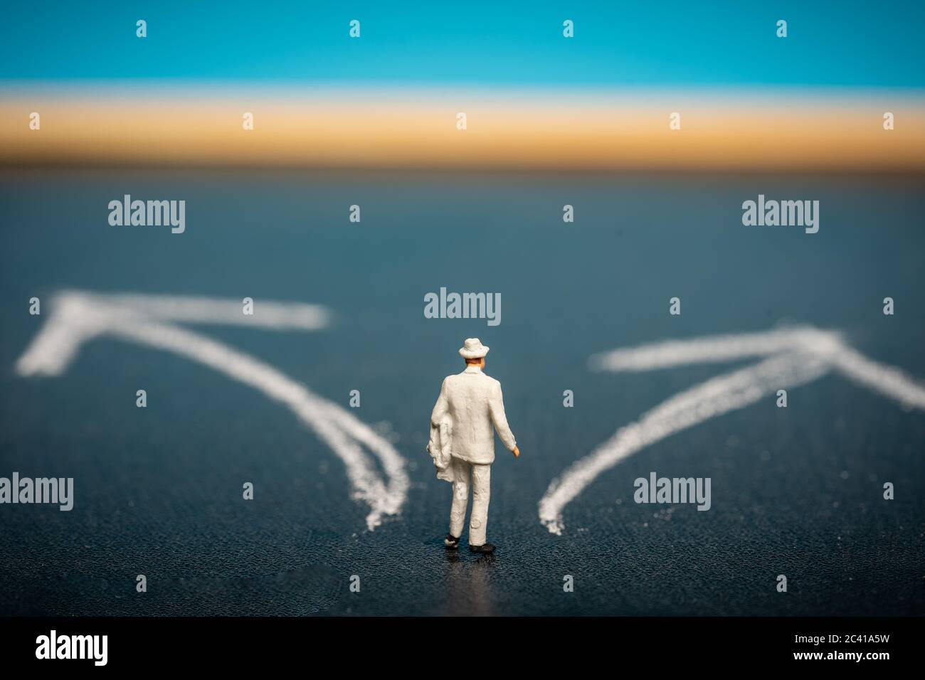 Business concept: Decision making. Miniature man on chalkboard with two ...