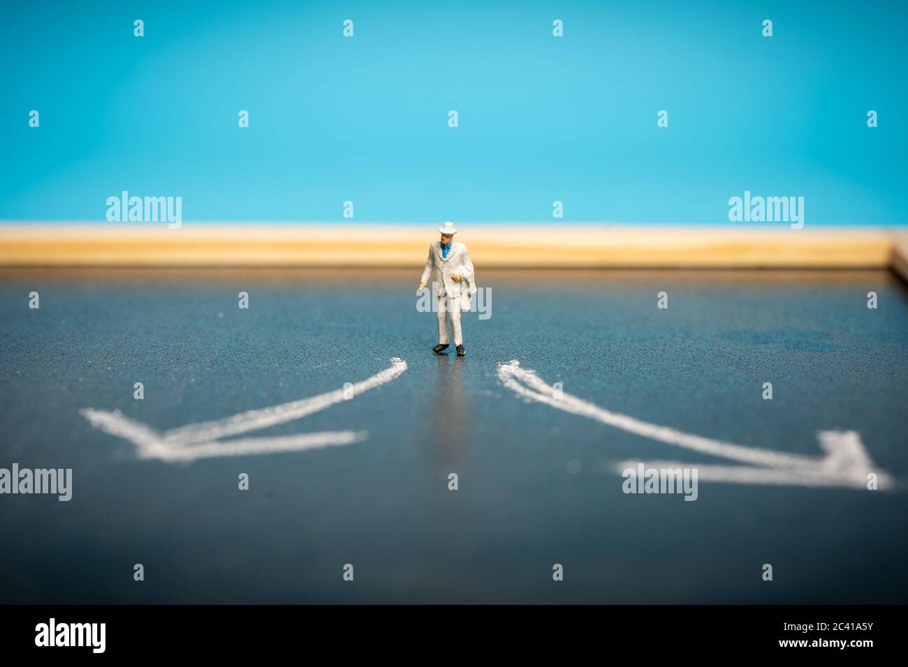 Business concept: Decision making. Miniature man on chalkboard with two ...
