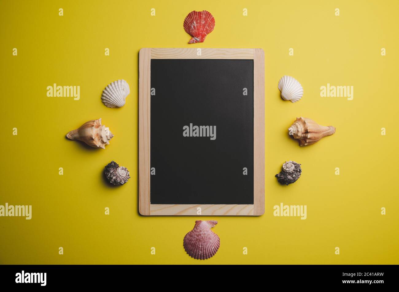 Ocean inspired flat lay composed of a blackboard, sea shells on yellow ...