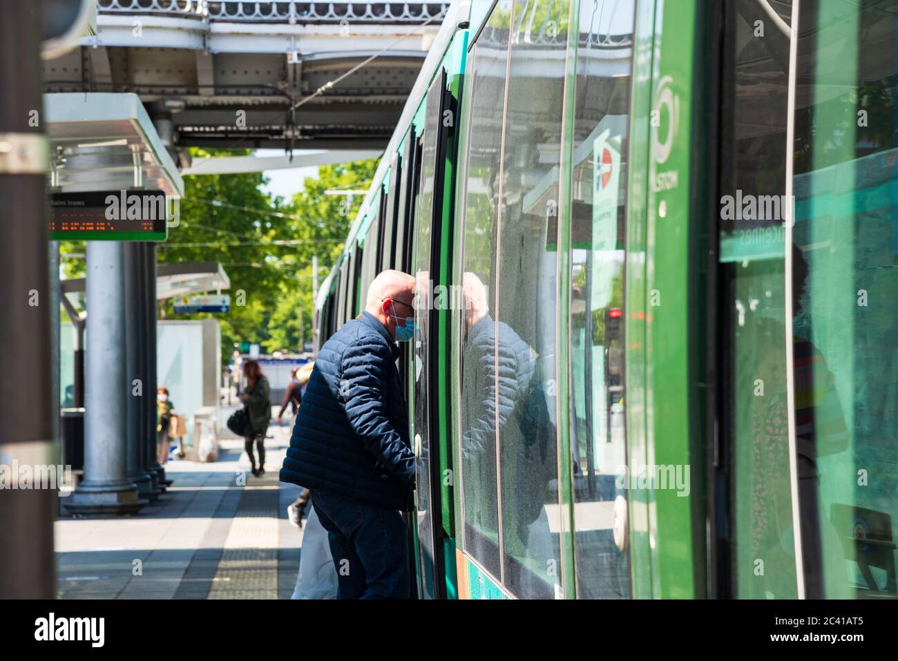 Paris, France - May 15, 2020: Senior man enters tram in Parisian suburb ...