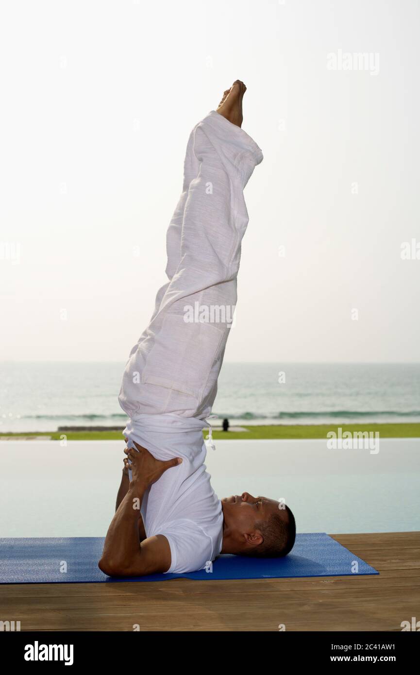 Asian man makes a candle on a terrace by the sea - concentration ...