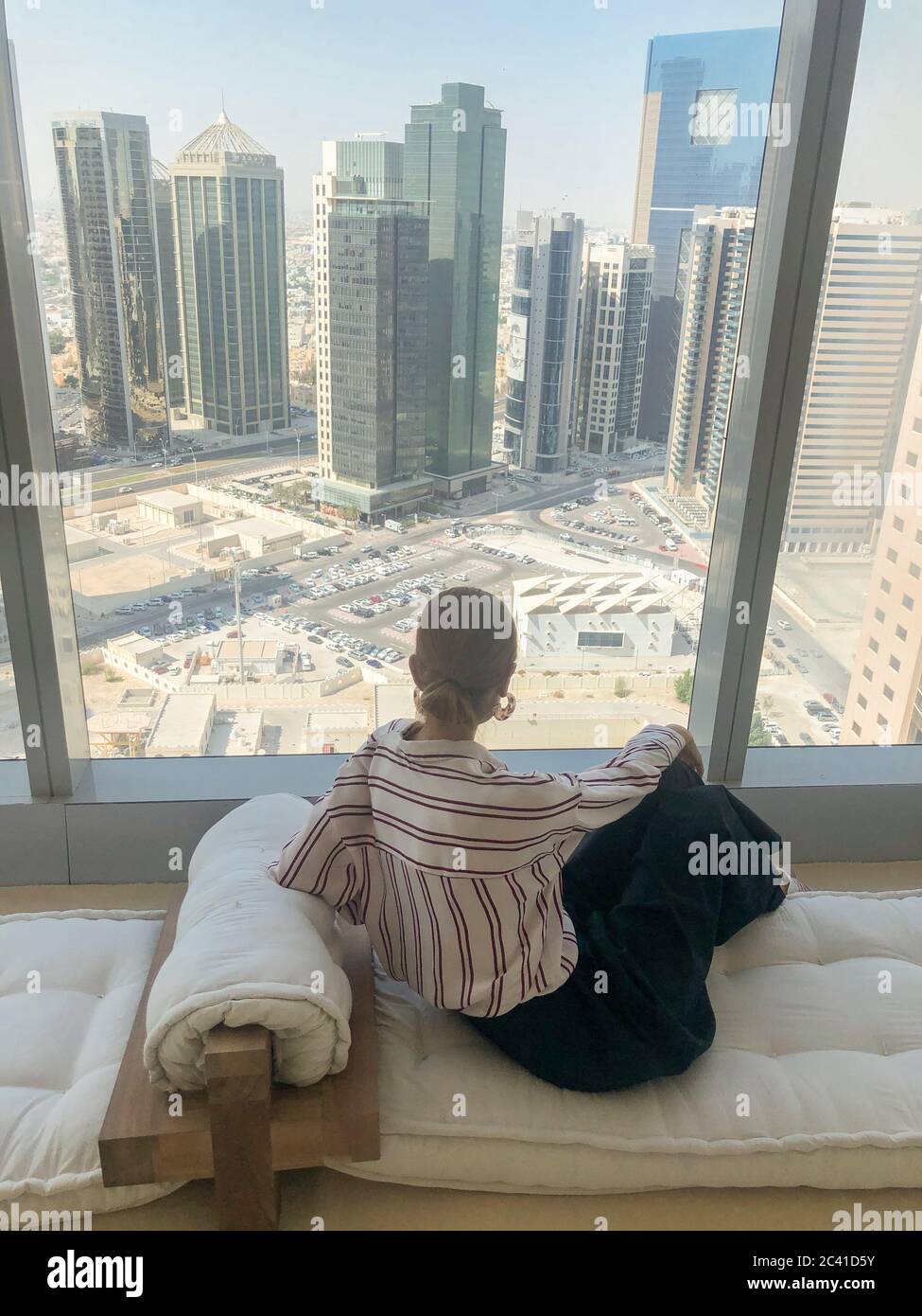 Back view of woman sitting and looking through window Stock Photo - Alamy