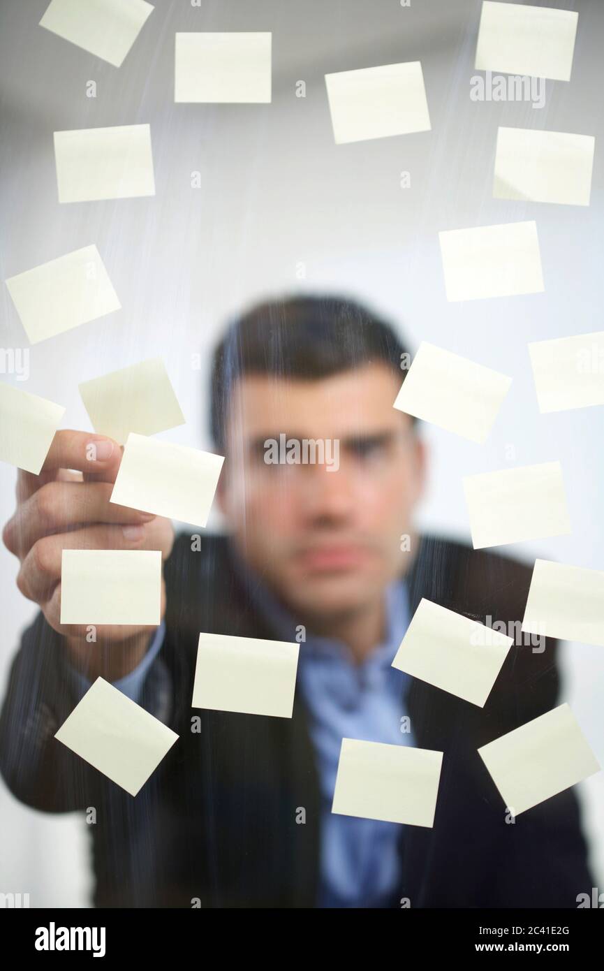 Man sticks sticky notes on a pane Stock Photo - Alamy