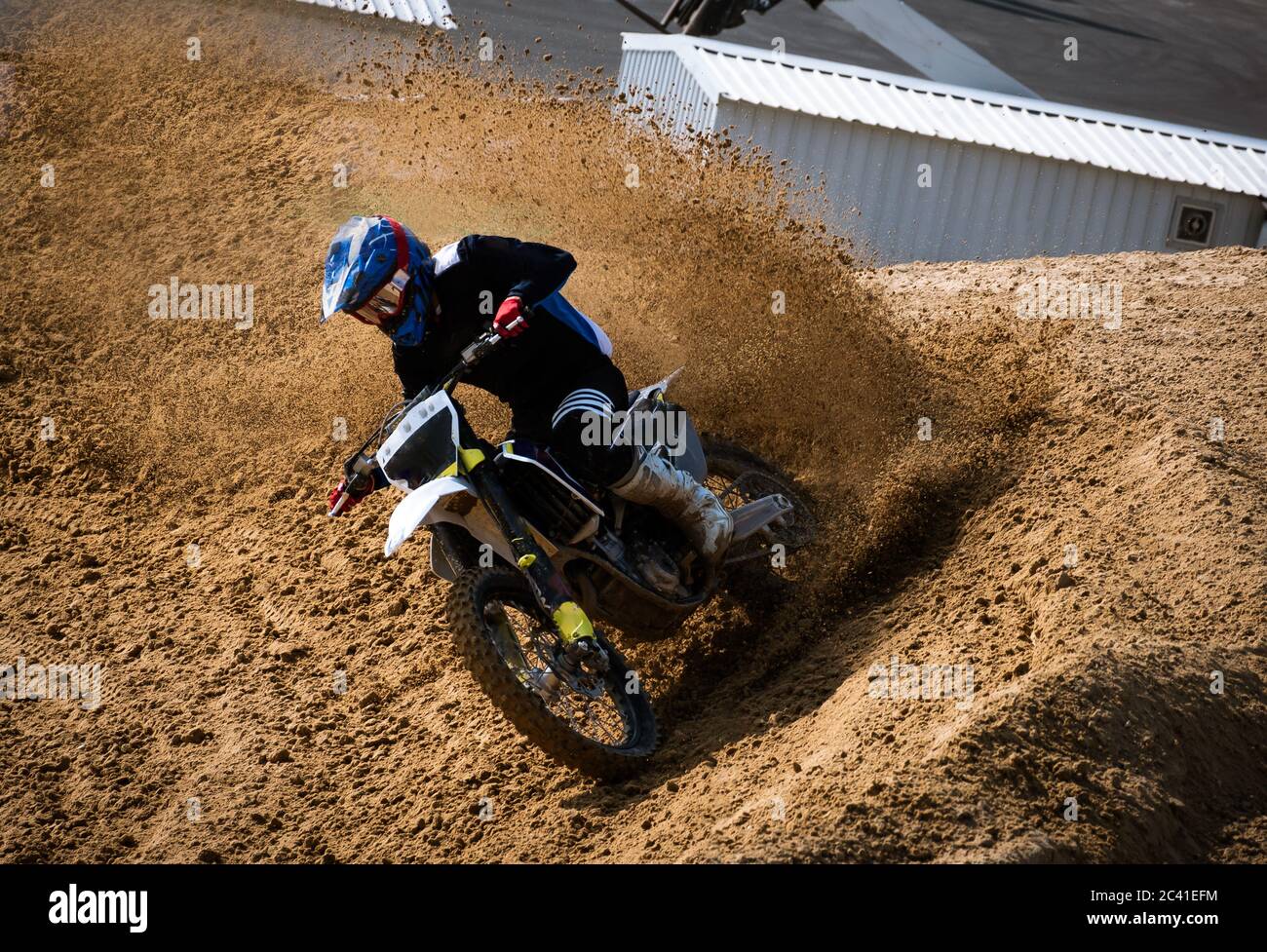 A rider on motorcycle turning and accelerating throwing the dust from ...