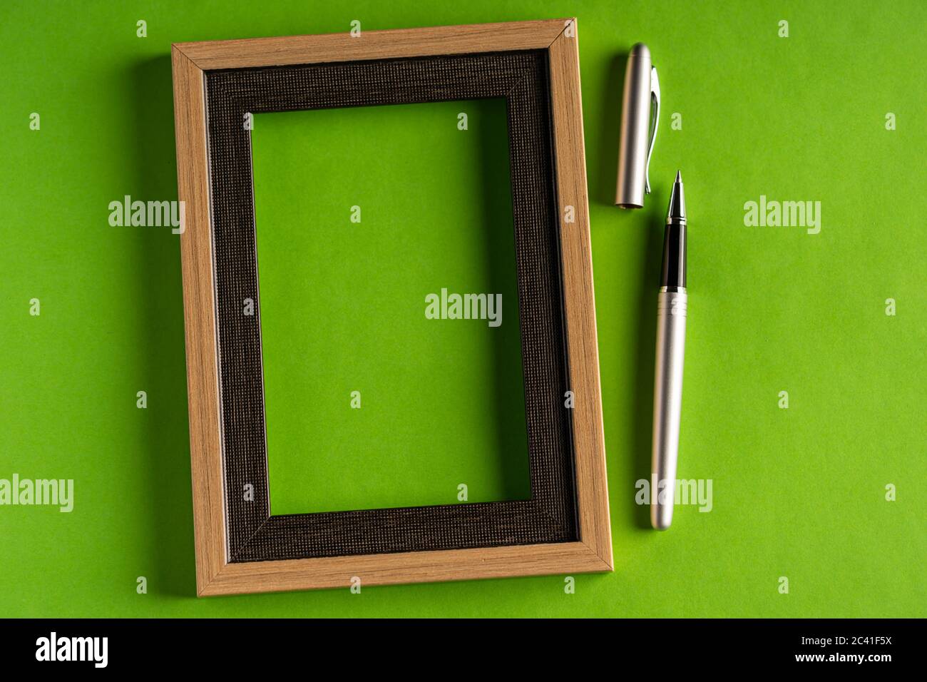 Classy silver pen and empty frame against green background Stock Photo ...