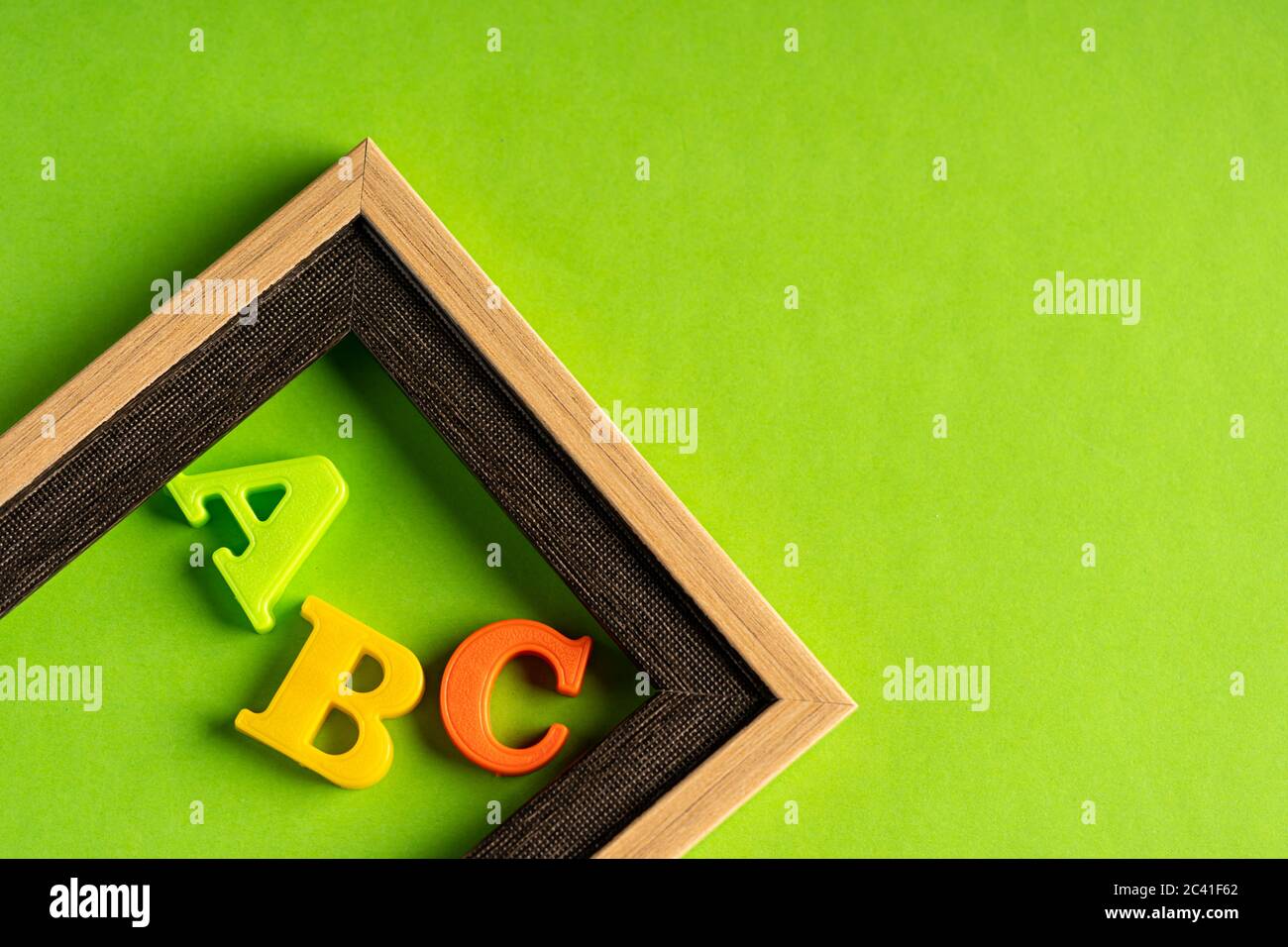 ABC and empty photo frame against green background Stock Photo - Alamy