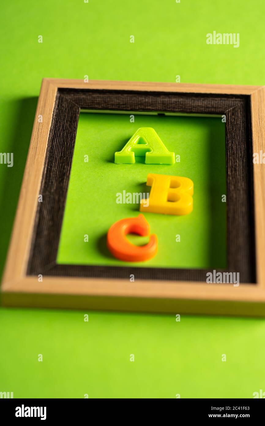 ABC and empty photo frame against green background Stock Photo - Alamy