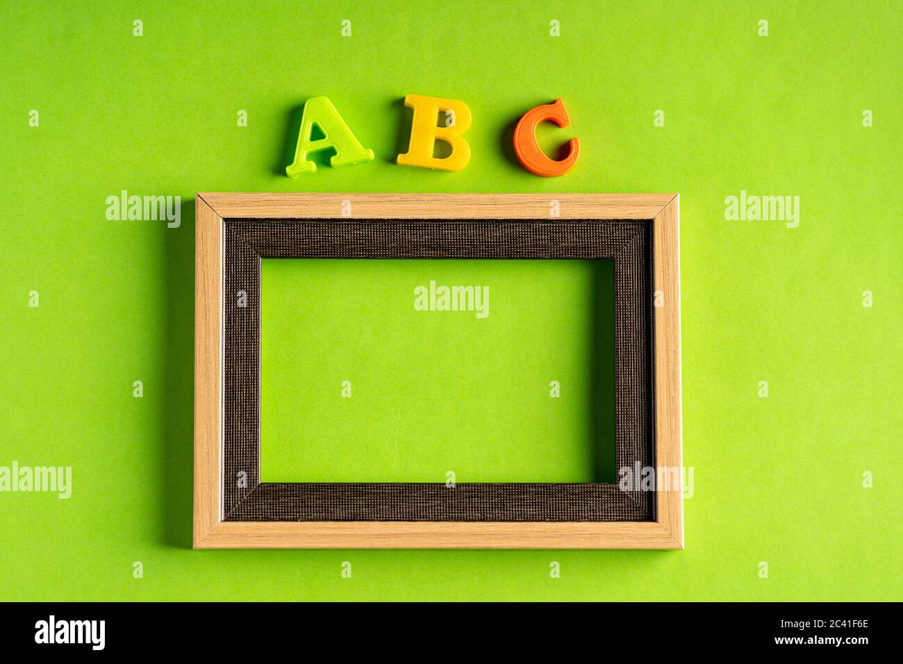 ABC and empty photo frame against green background Stock Photo - Alamy