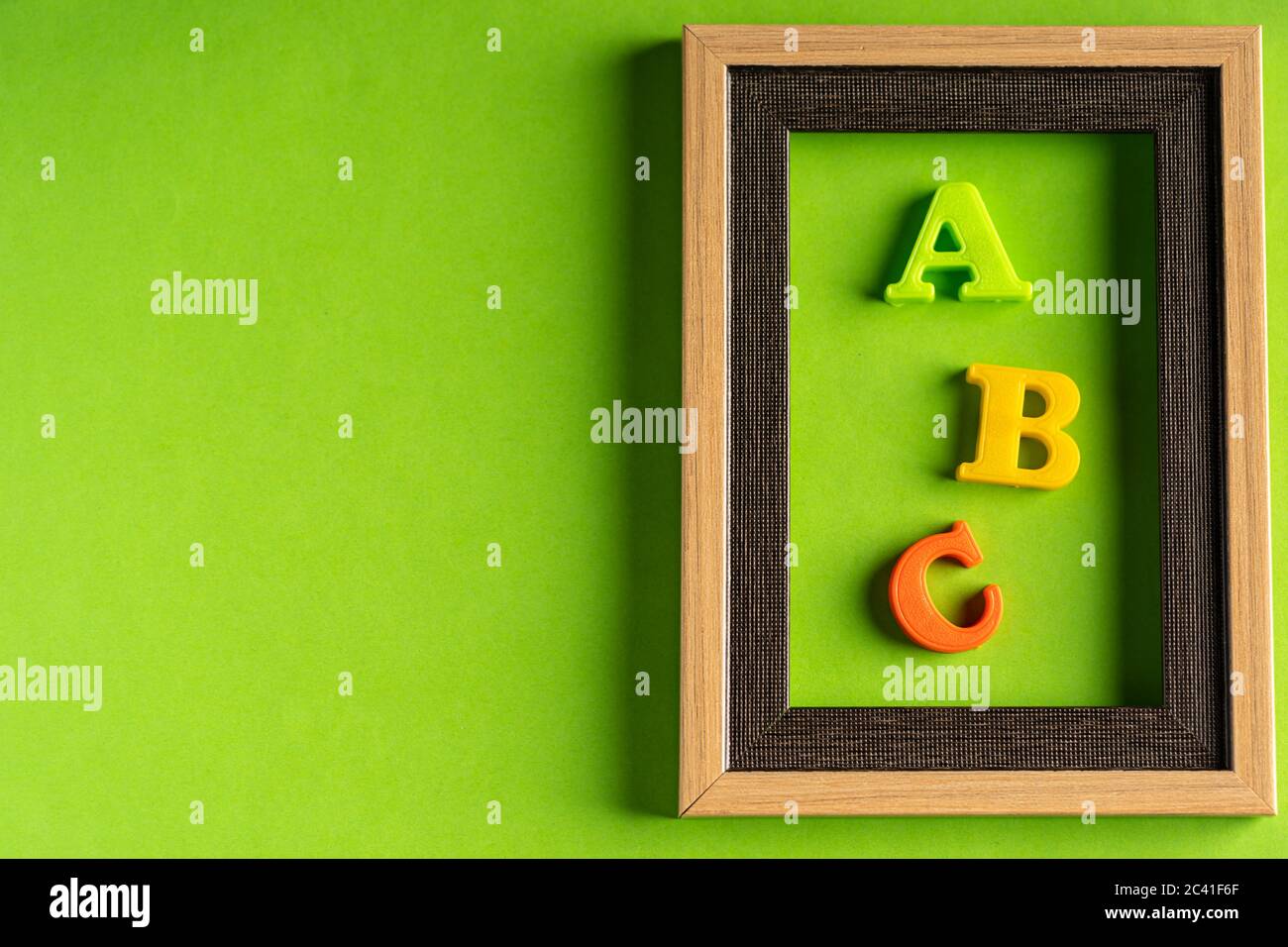 ABC and empty photo frame against green background Stock Photo - Alamy