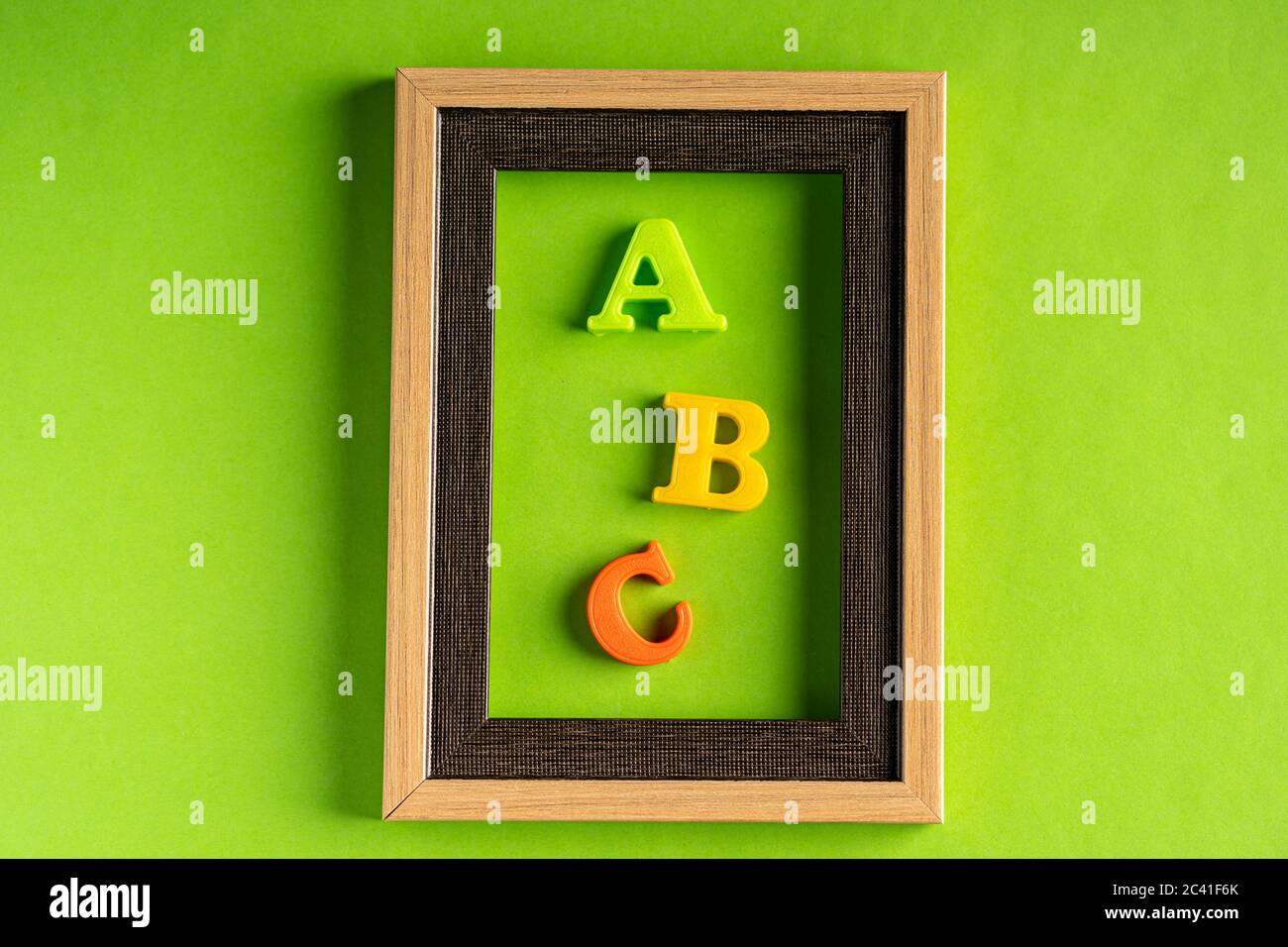 ABC and empty photo frame against green background Stock Photo - Alamy