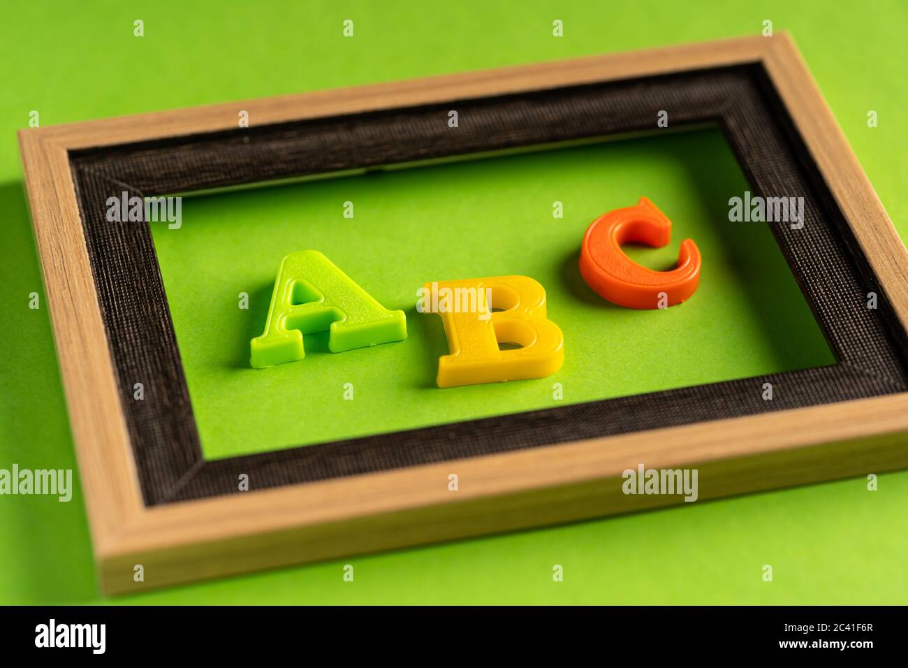 ABC and empty photo frame against green background Stock Photo - Alamy