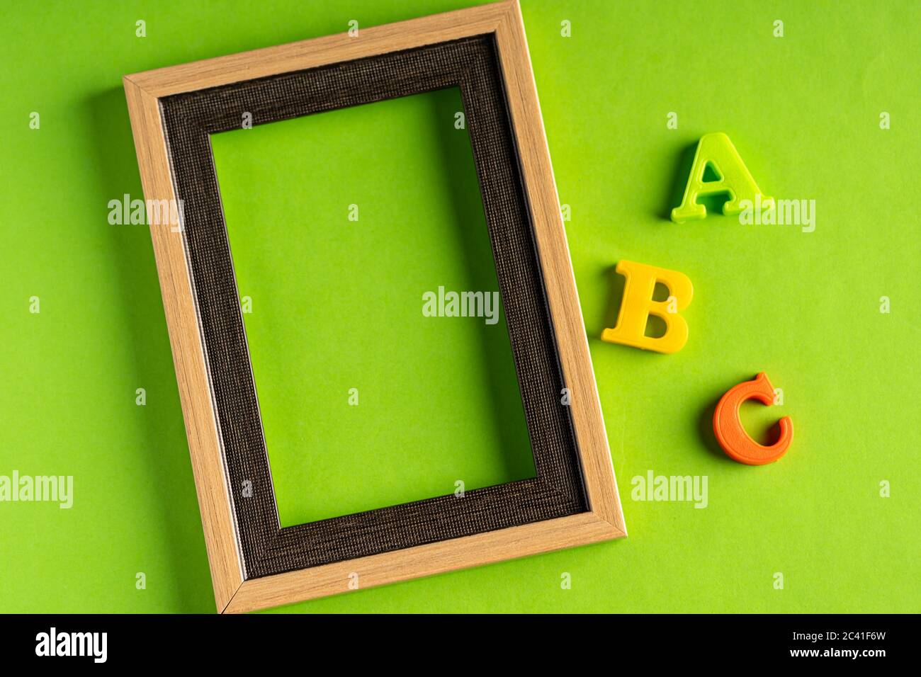 ABC and empty photo frame against green background Stock Photo - Alamy