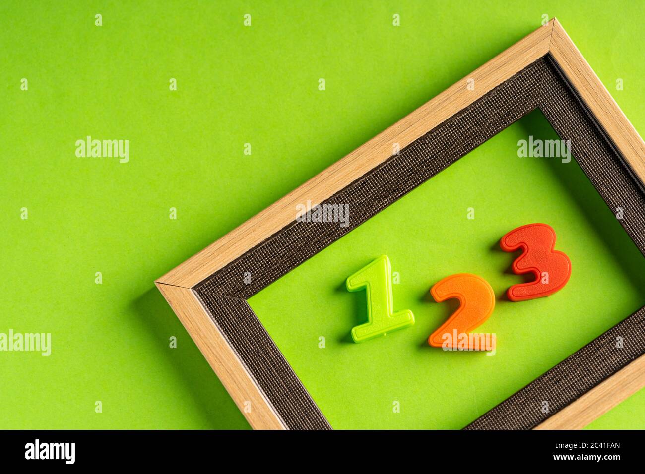 123 and empty photo frame against green background Stock Photo - Alamy