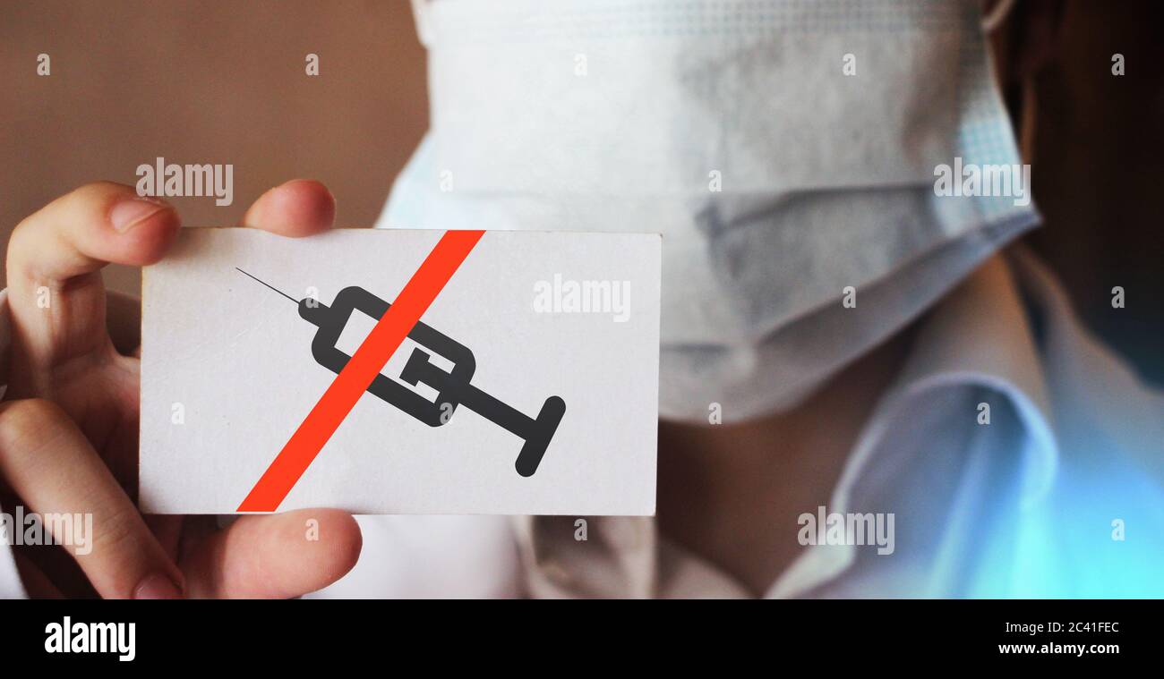 Syringe icon crossed out on card in doctor hands. Doctor wears surgical ...