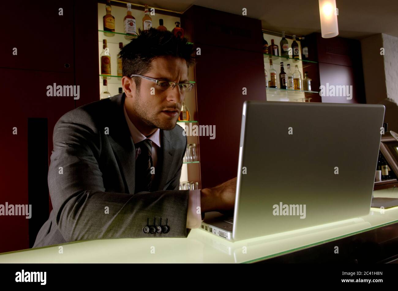 Businessman works in a bar on a laptop Stock Photo - Alamy
