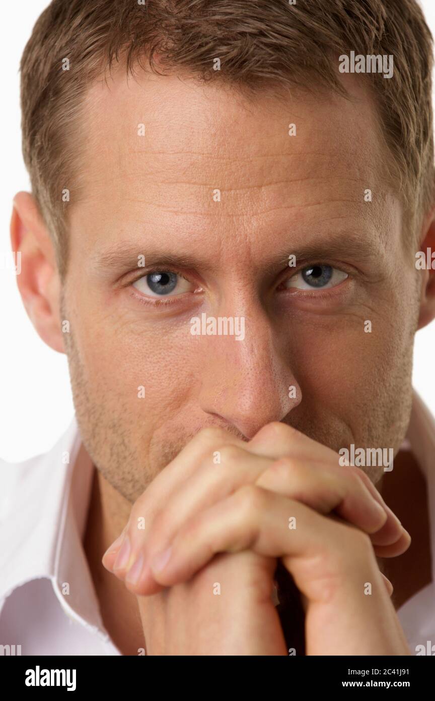 Man with clasped hands - facial expressions Stock Photo - Alamy