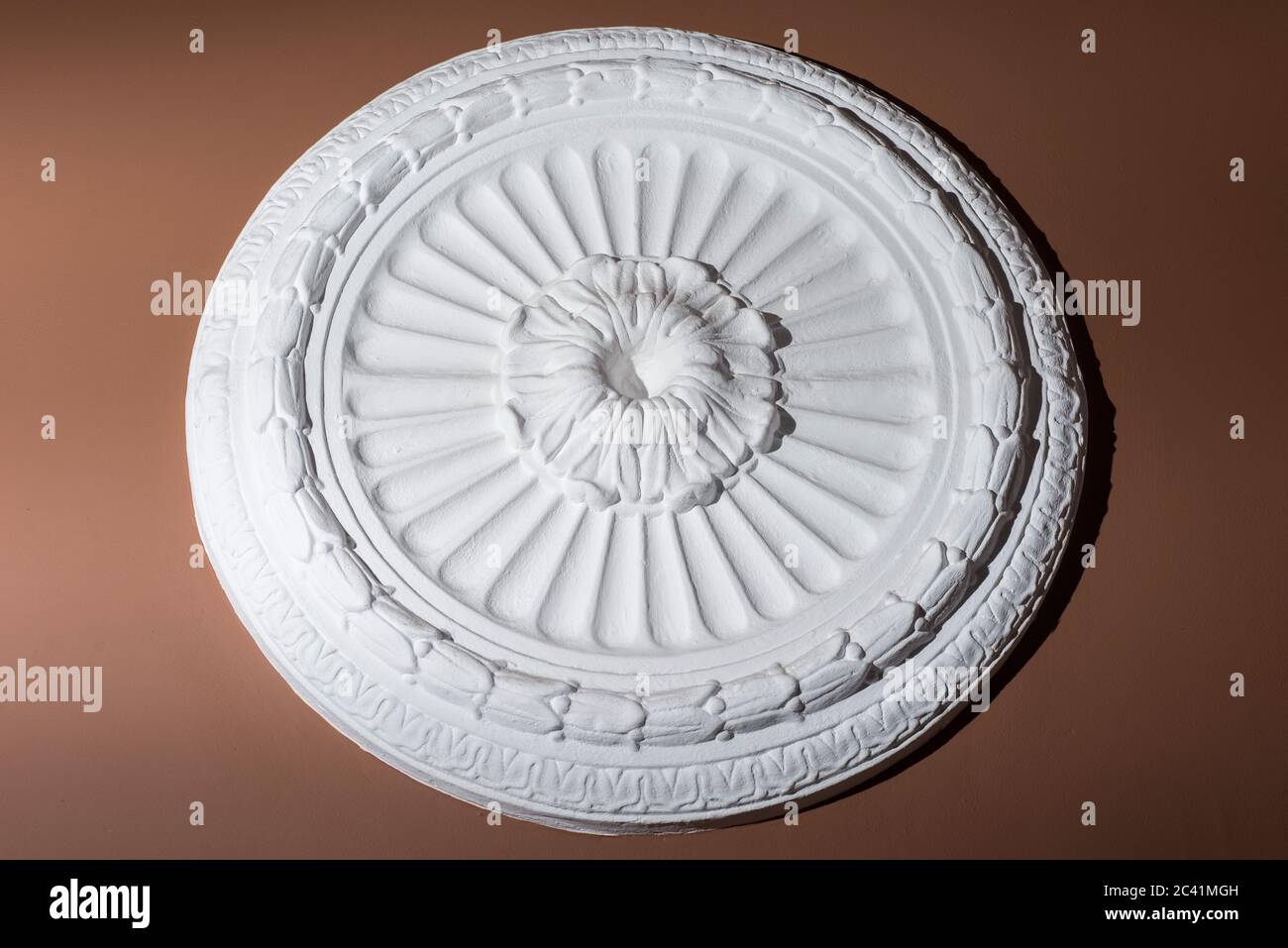 architectural decorative finish on a brown wall, white, round gypsum ...