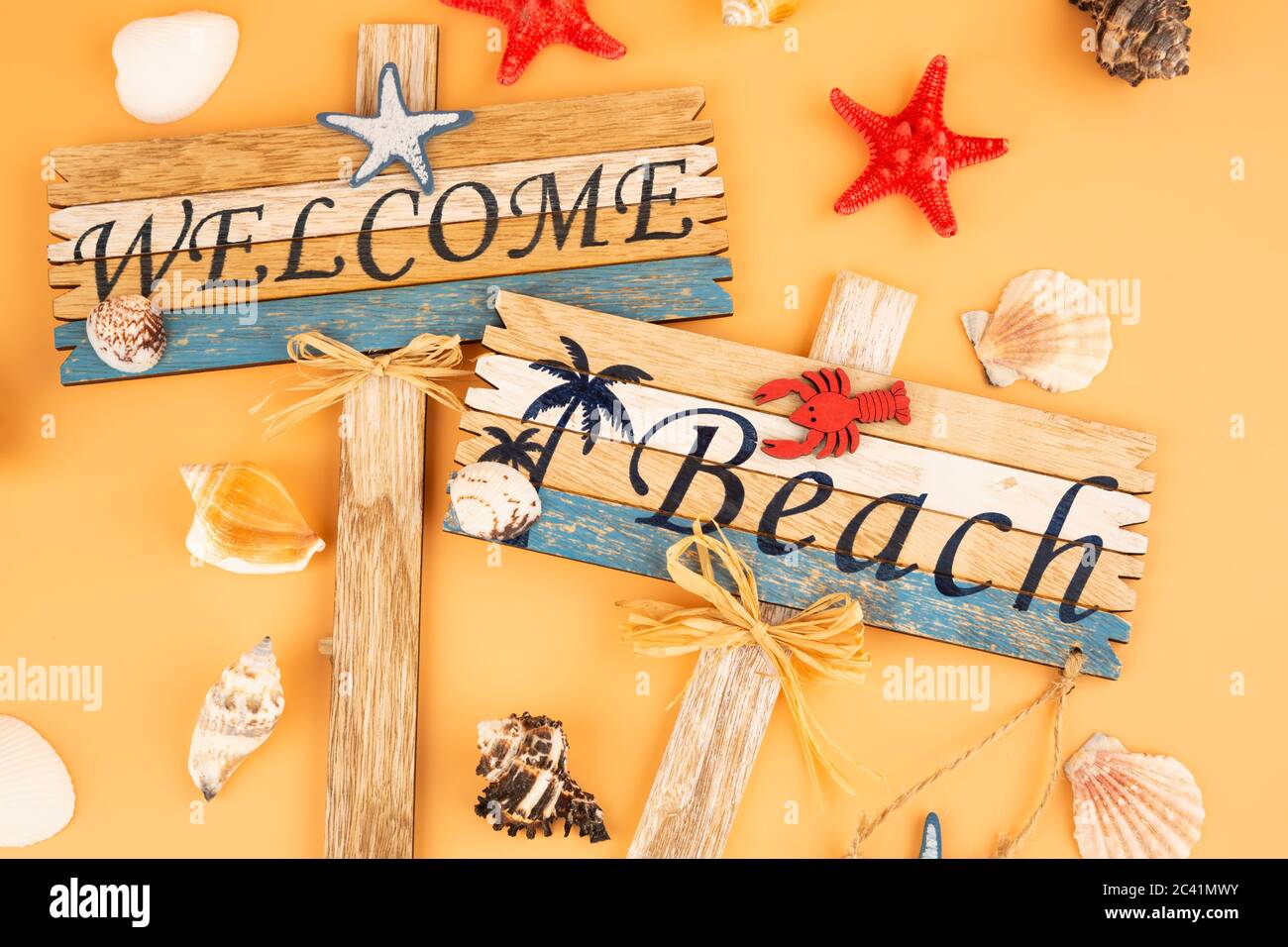 Wooden signs welcome beach, starfish and shells on yellow background ...