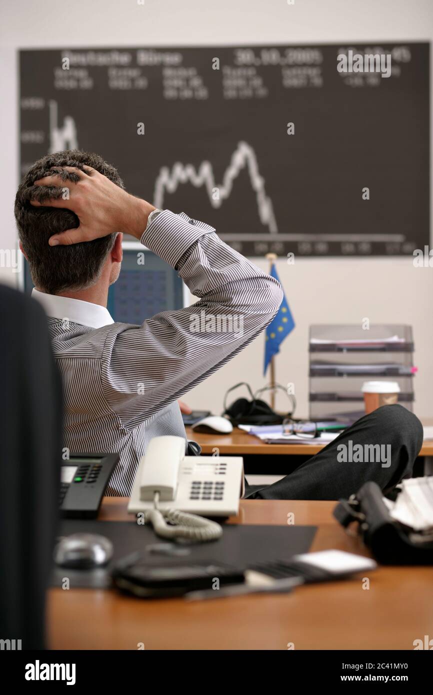 Stockbroker looks at scoreboard Stock Photo - Alamy