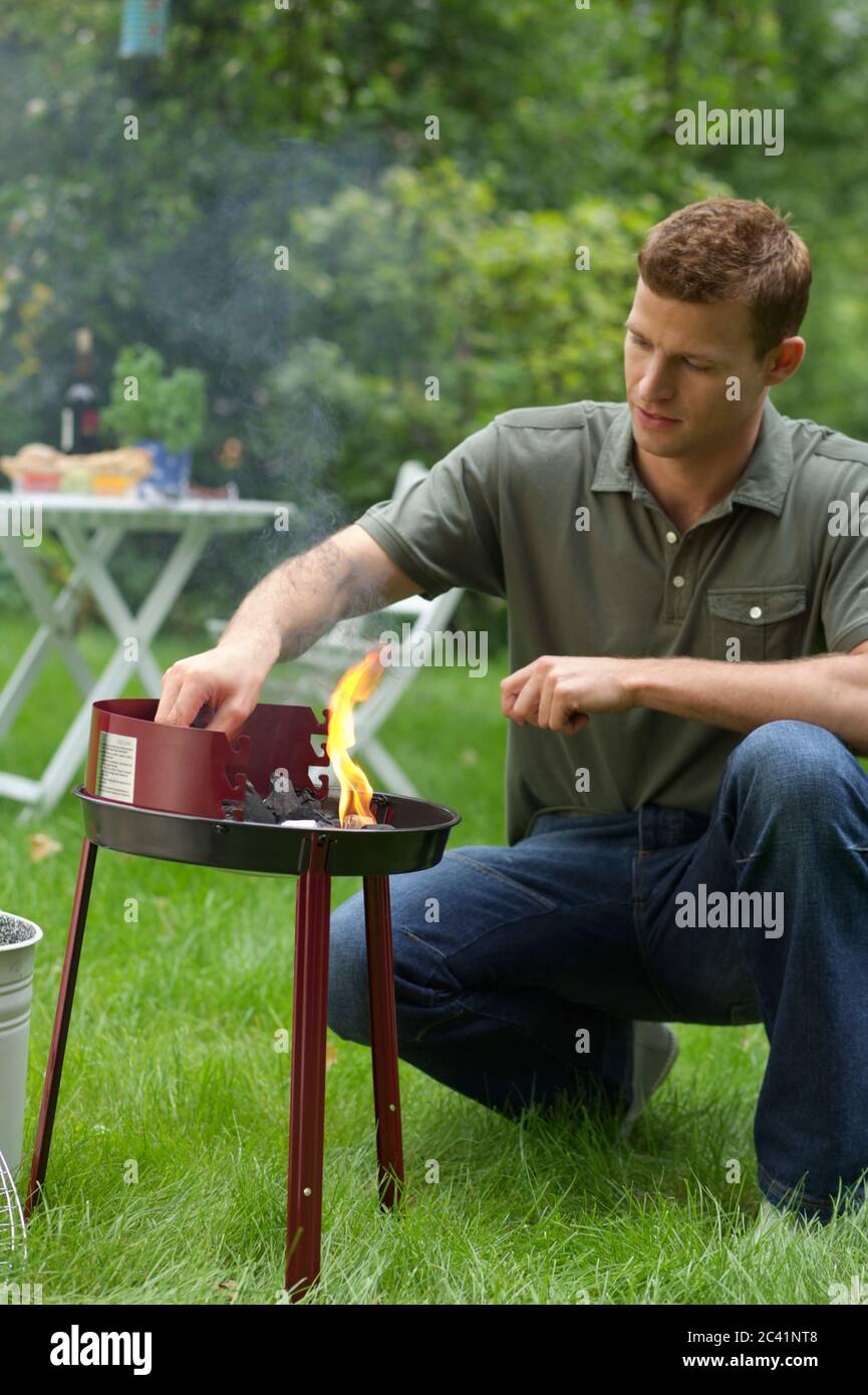 Young man lights fire Stock Photo - Alamy