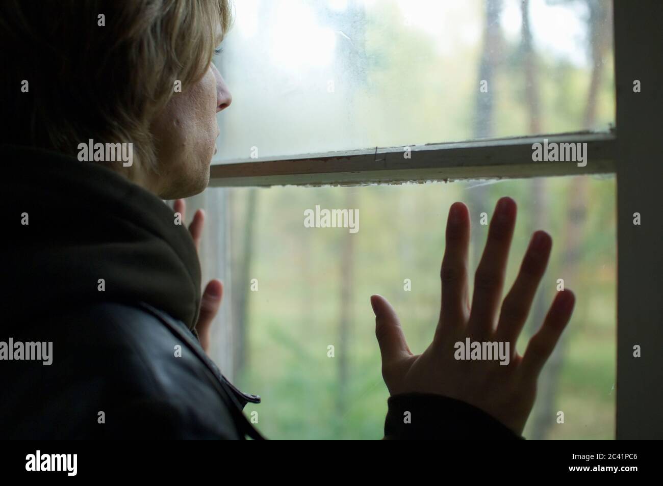 Man looks out of a window Stock Photo - Alamy
