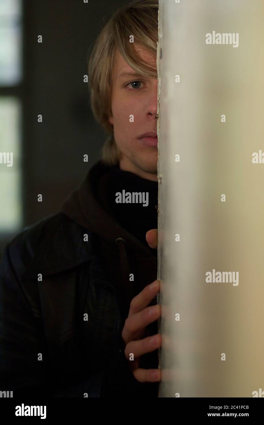 Man looks around a corner Stock Photo - Alamy