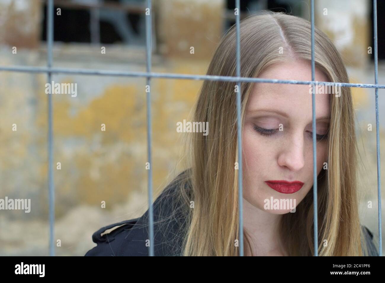 Young woman behind a chain link fence Stock Photo - Alamy